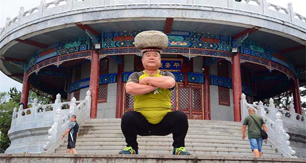Man Exercises with 40kg Stone on His Head